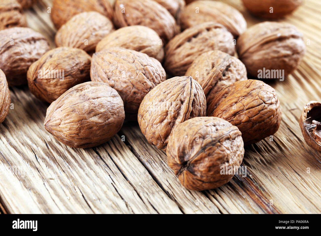 Walnut kernels and whole healthy walnuts on rustic old table Stock ...