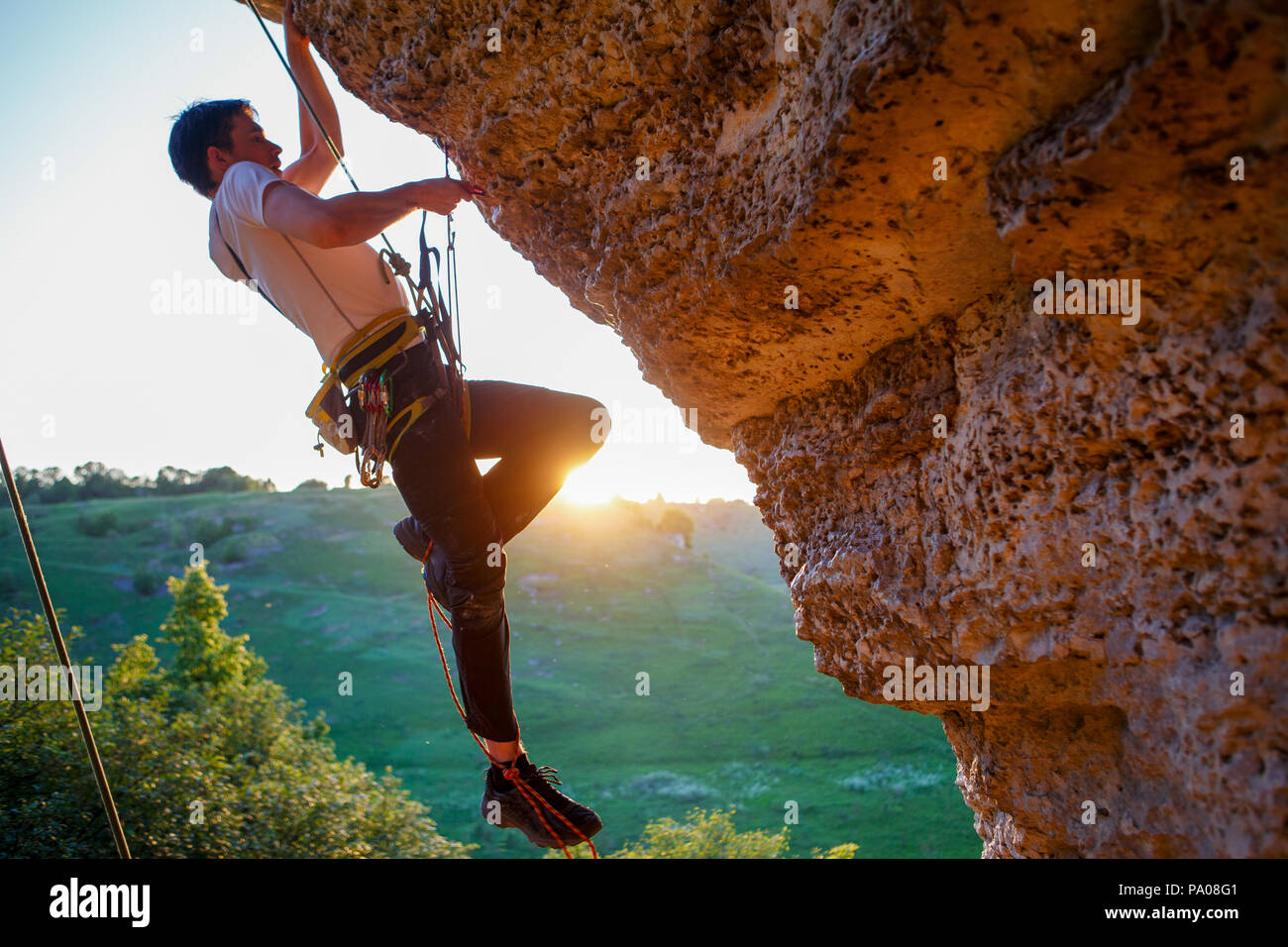 Picture of man clambering over rock Stock Photo - Alamy