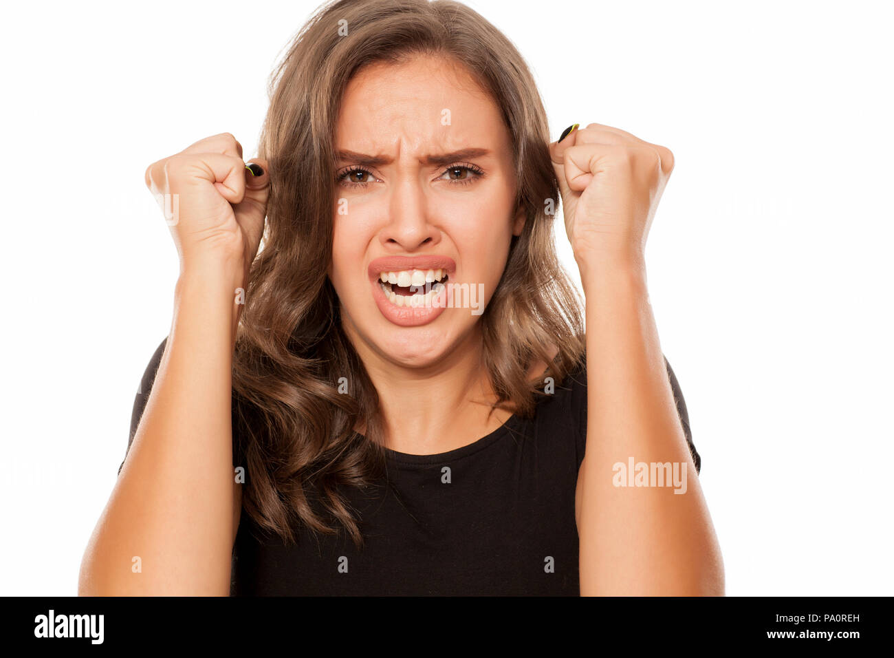 Portrait of beautiful young nervous woman on white background Stock ...