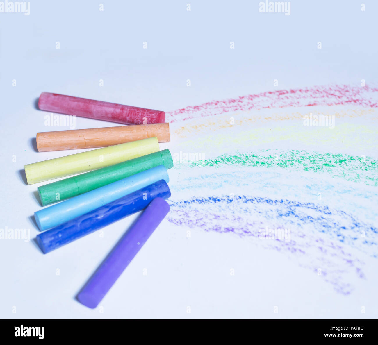 crayons to draw and color lines on a white sheet of paper Stock Photo ...