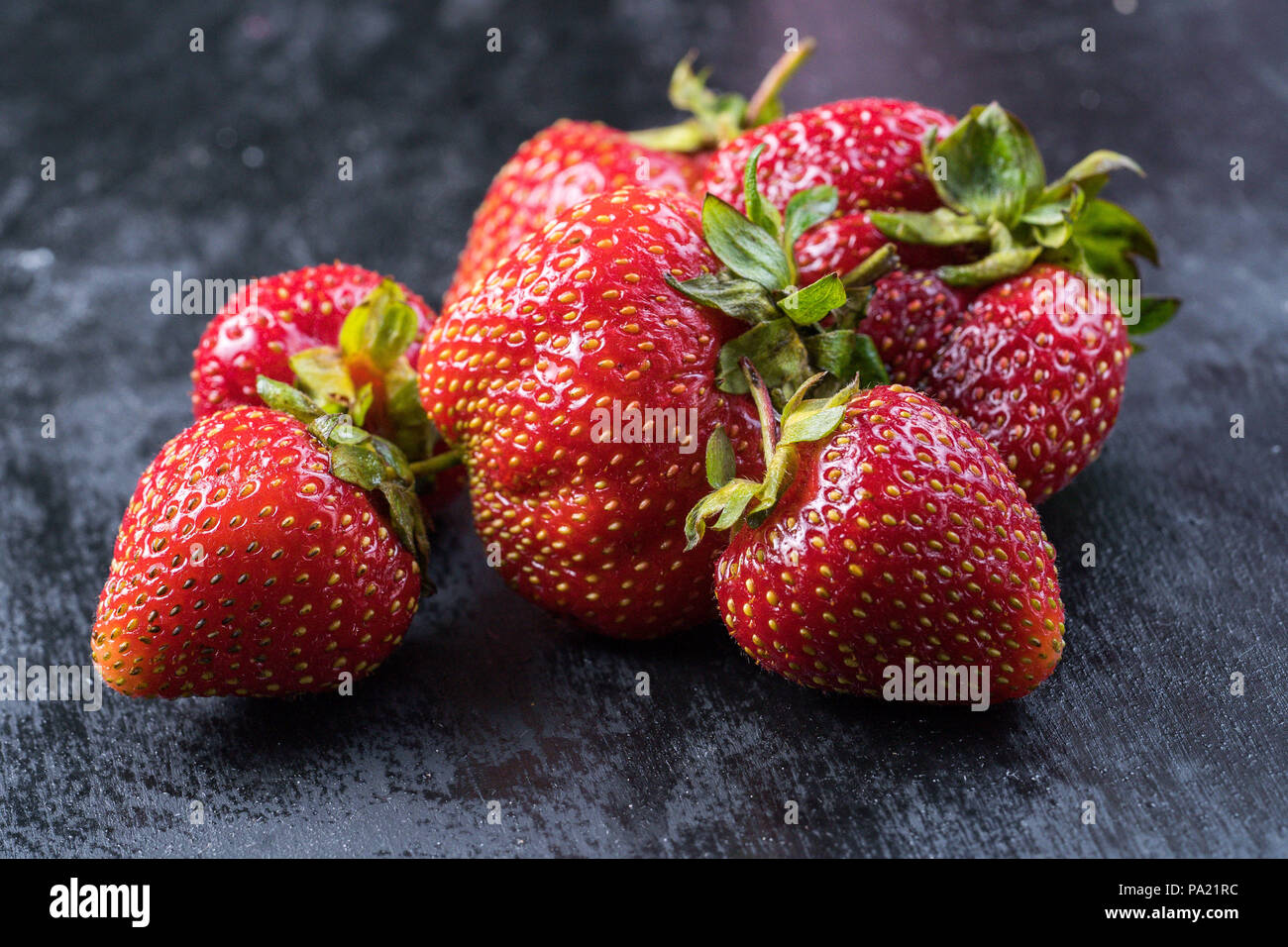 Fresh red strawberry on black stone plate in dark background Stock ...