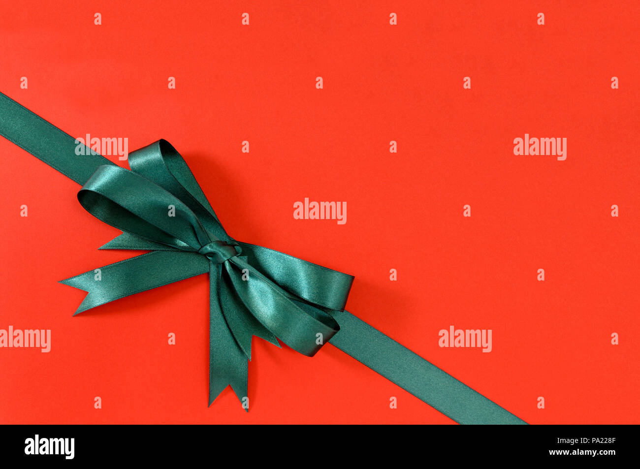Green gift ribbon bow corner diagonal red paper background Stock Photo ...