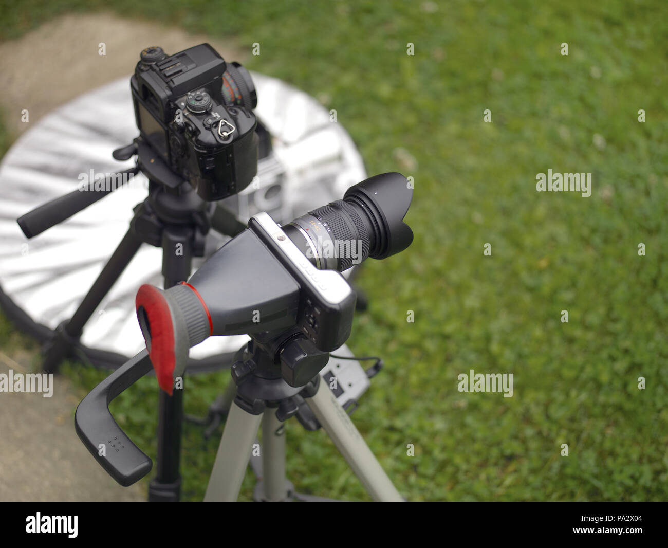 Photographer equipment on the tripods and a loght disc laid on the ...