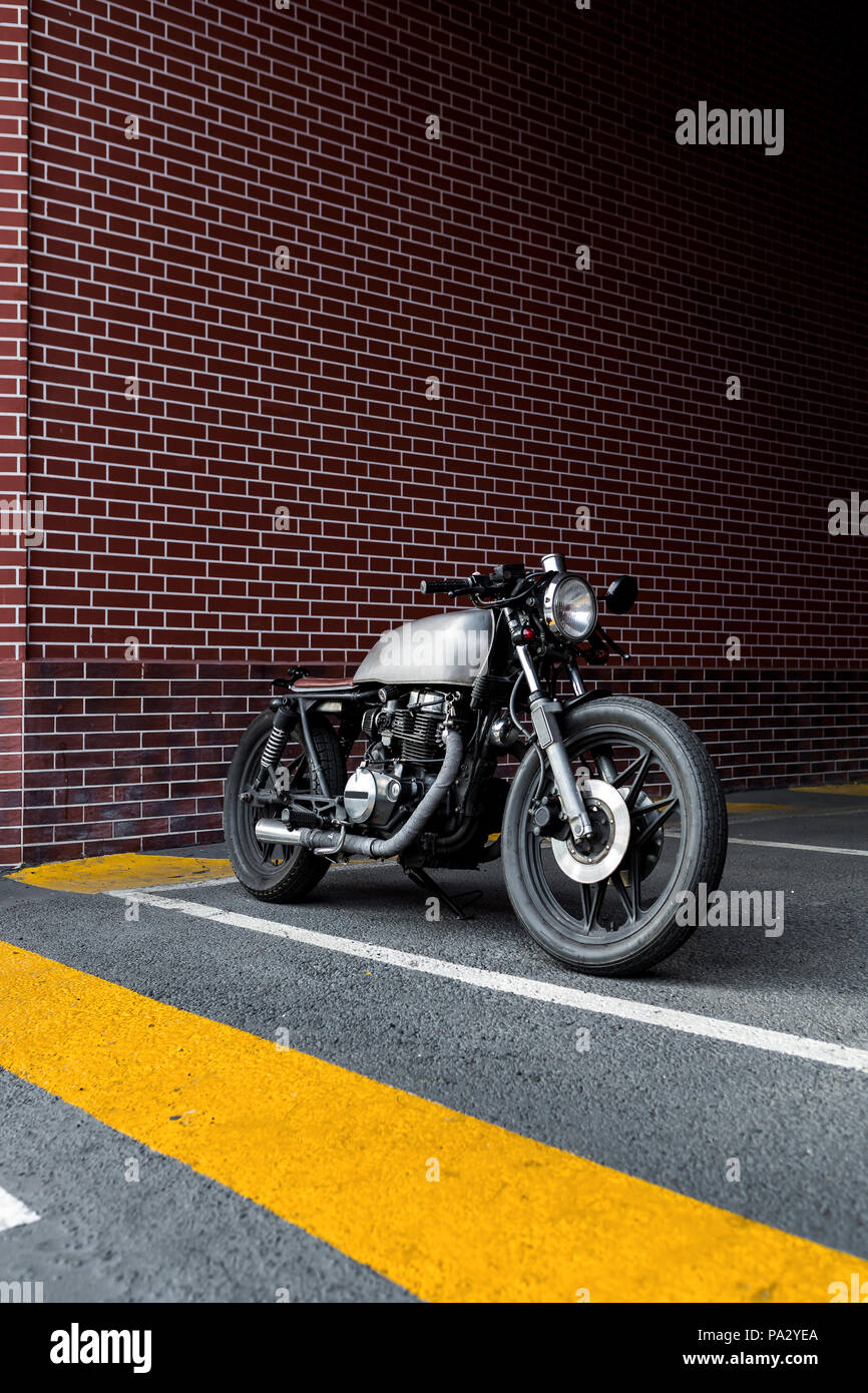 Custom motorcycle parking near brick wall of finance building ...