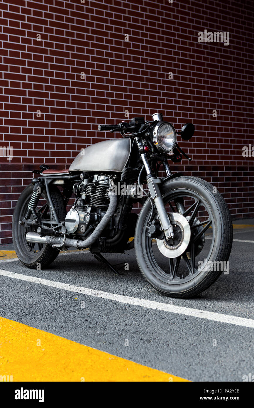 Caferacer motorcycle parking near brick wall of finance building ...