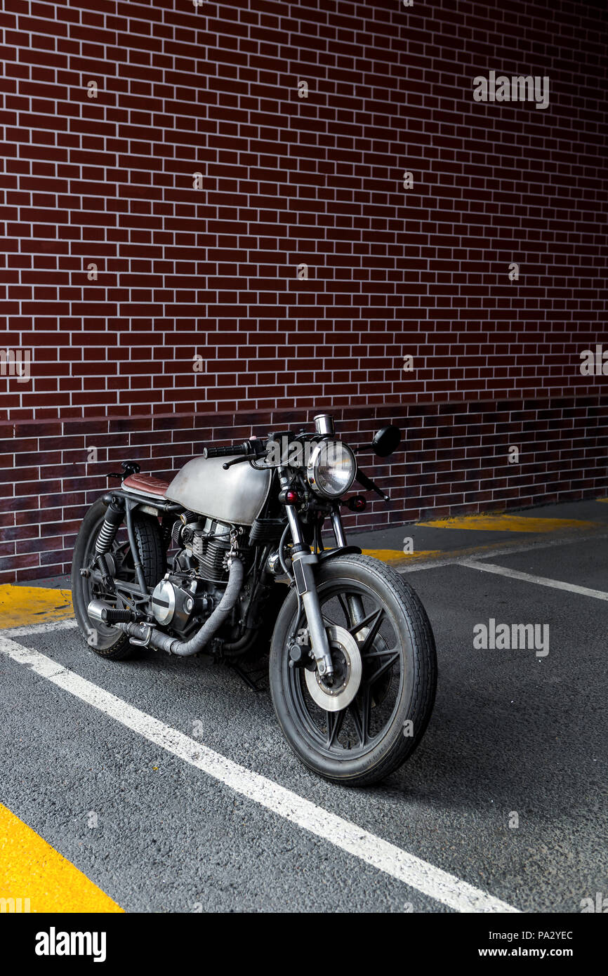 Custom motorbike parking near brick wall of finance building ...