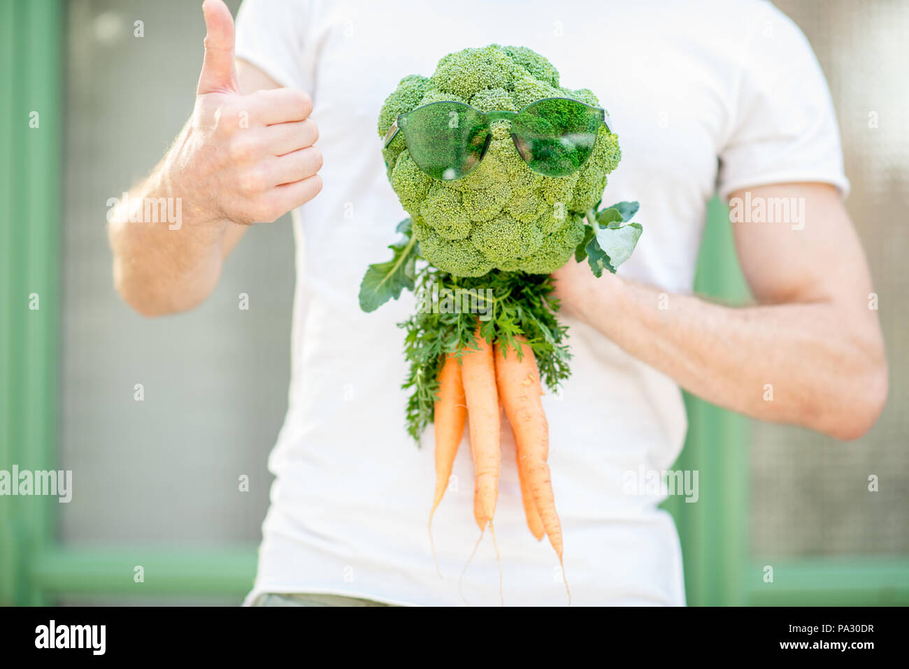 Holding broccoli with carrot like a vegetable person, healthy eating ...
