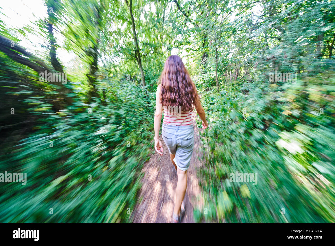 Woman running through a forest in Pfaffenhofen a.d.Ilm, Germany July 20 ...