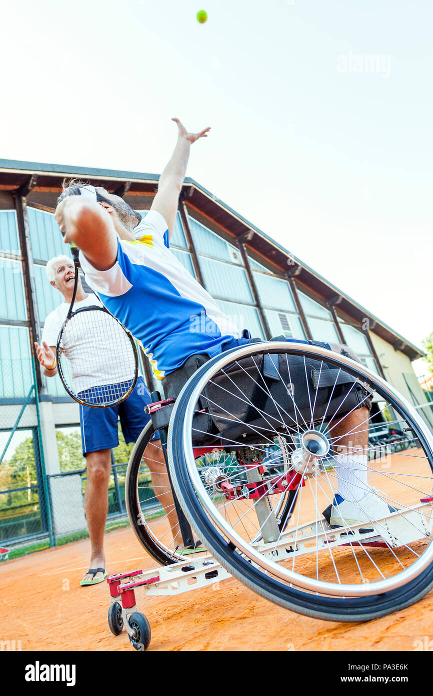 tennis coach teaching a disabled player the correct movement of the ...
