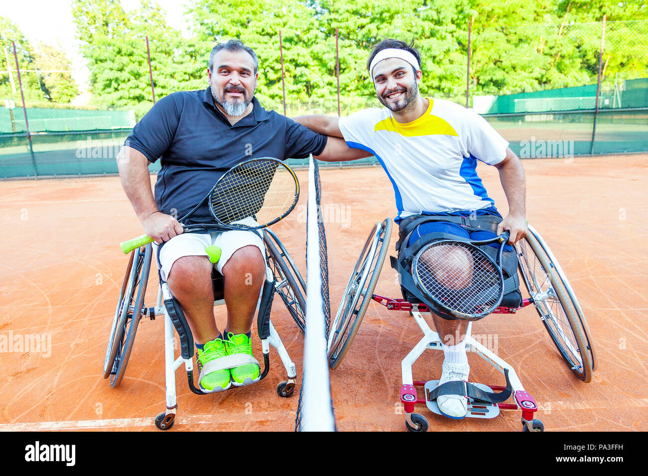 pair of disabled tennis players hugging each other under the net after ...
