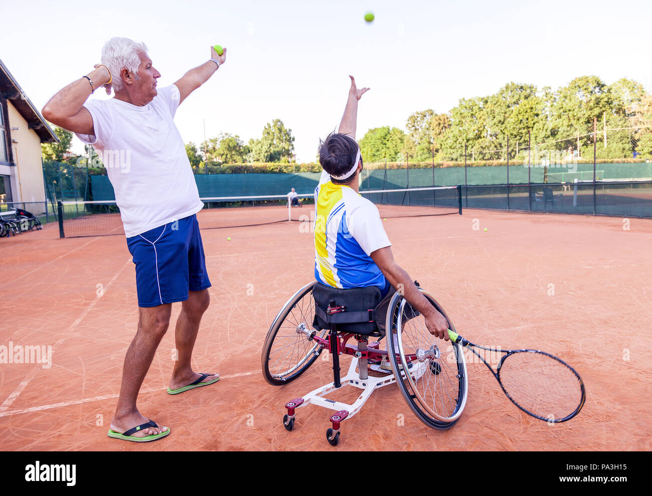 tennis coach teaching a disabled player the correct movement of the ...