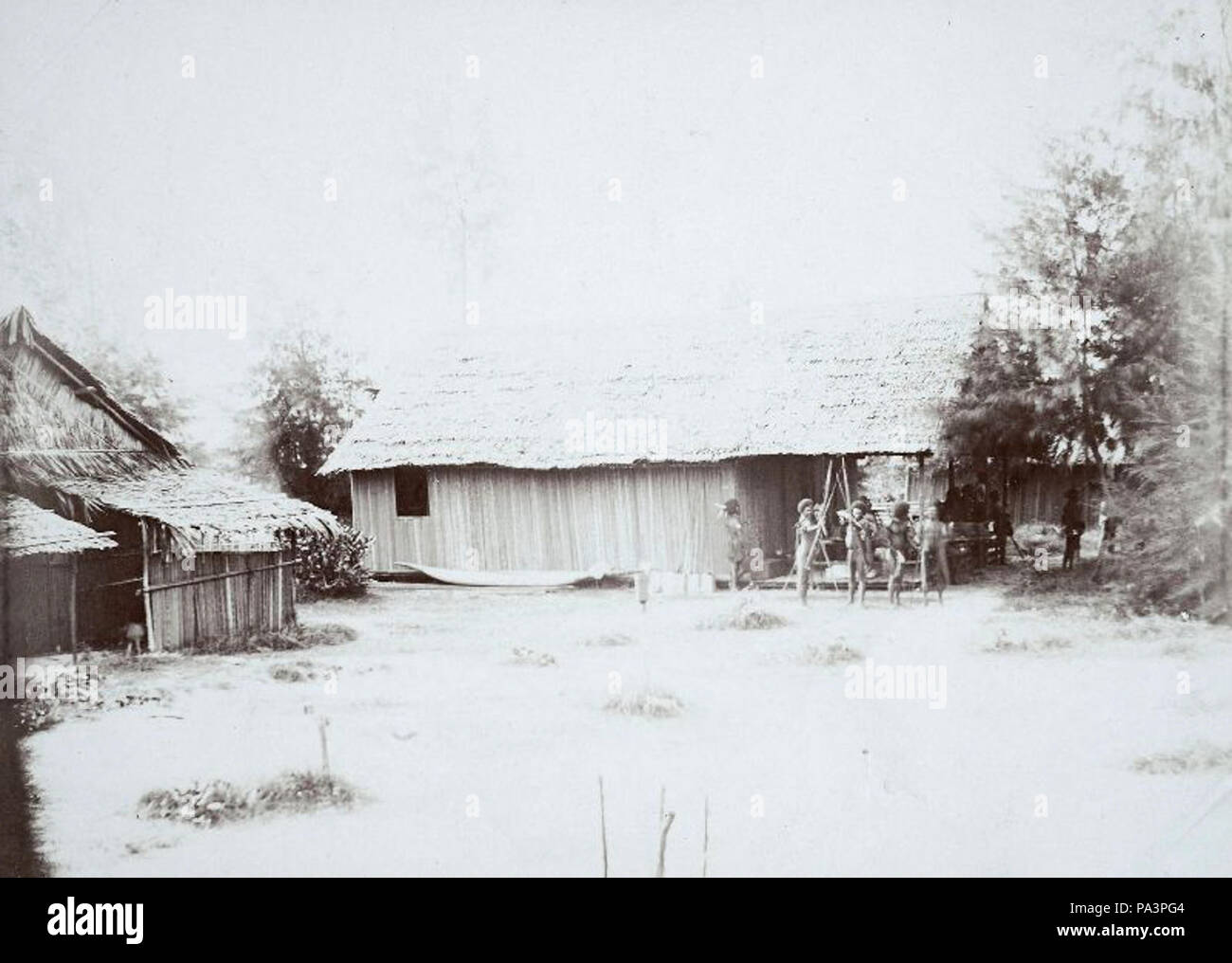 191 Papua's schieten met pijl en boog op het erf voor het huis van de ...