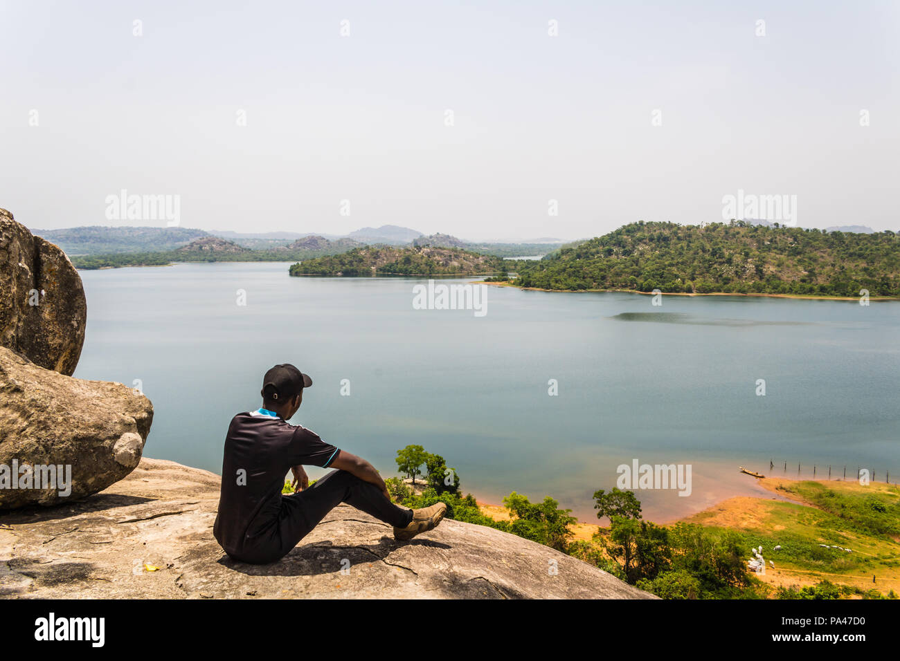 Sitting on an outcropped rock on the top of a mountain looking out ...