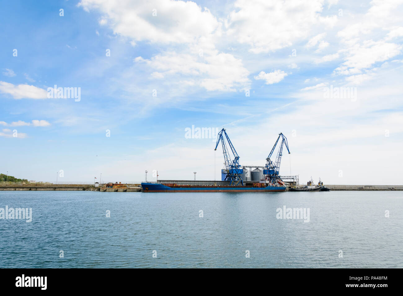 Crane and cargo ship in the Balchik bay in Bulgaria Stock Photo - Alamy