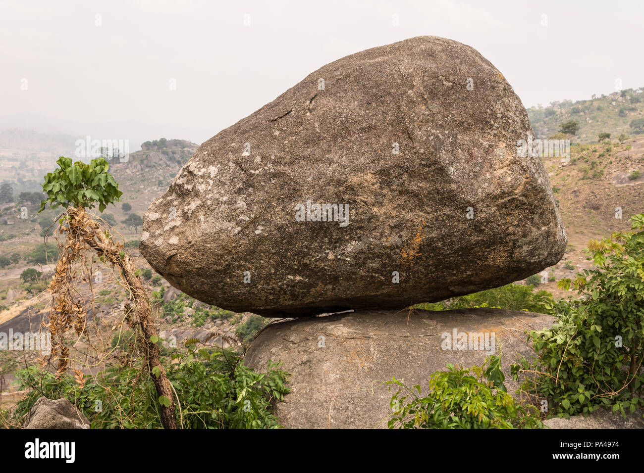 A massive rock perched at the top of a mountain overlooking a ...