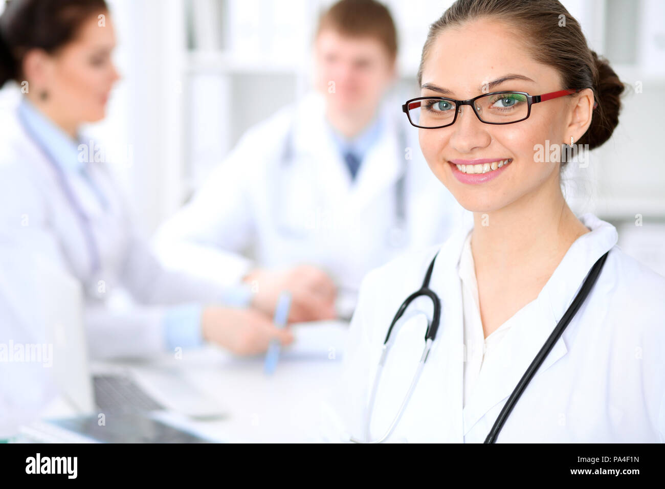 Female doctor working with medical staff at hospital. Teamwork in ...