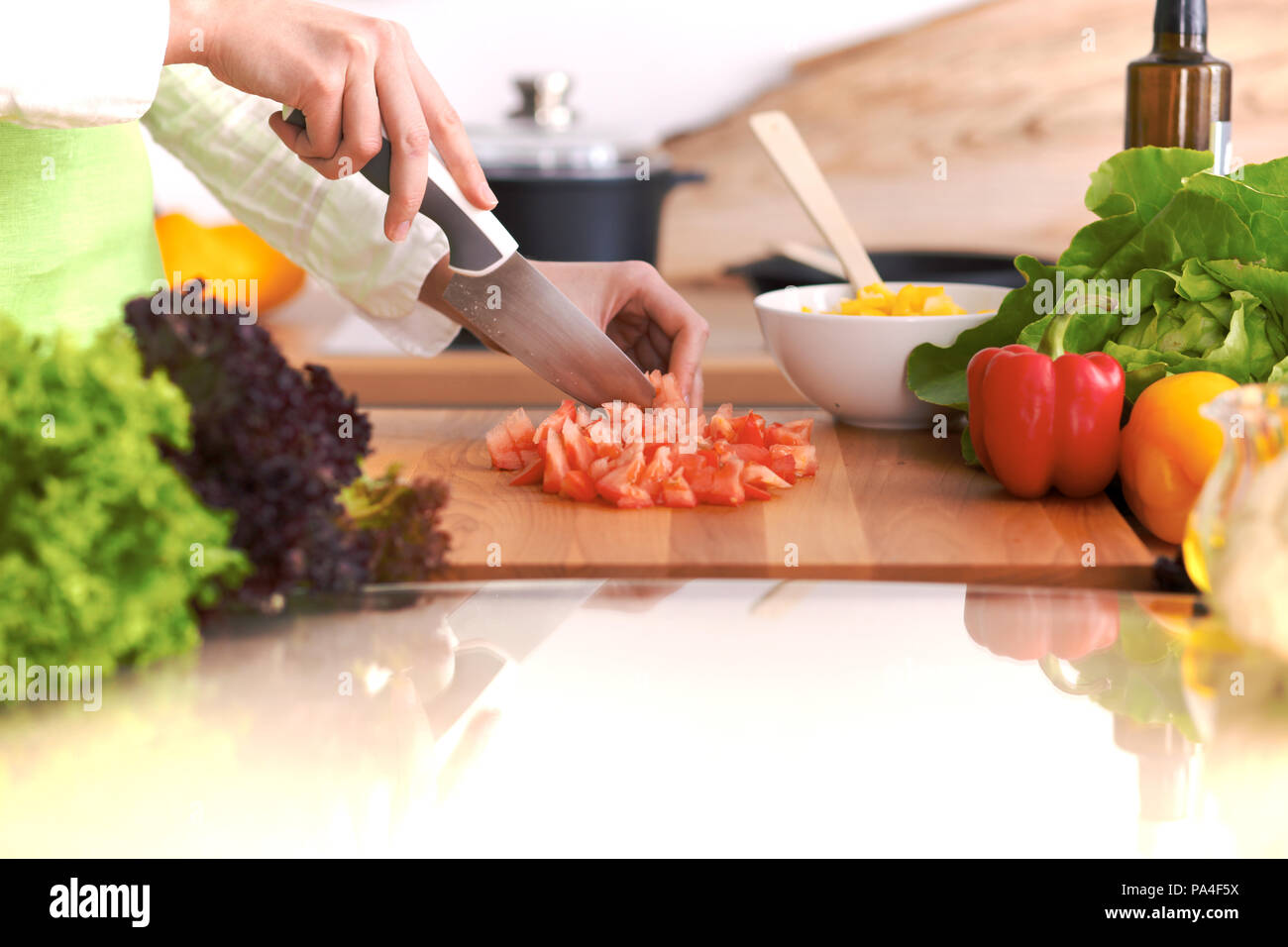 Close Up of human hands cooking vegetable salad in kitchen on the glass ...