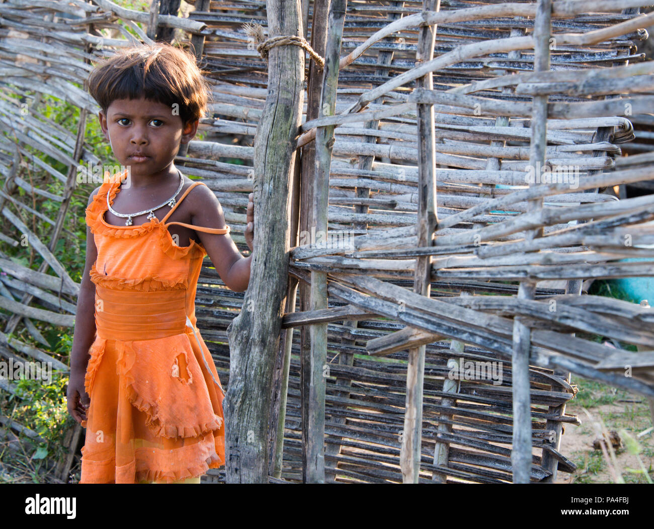 A local indian girl stands outside her house to see tourists walking by ...