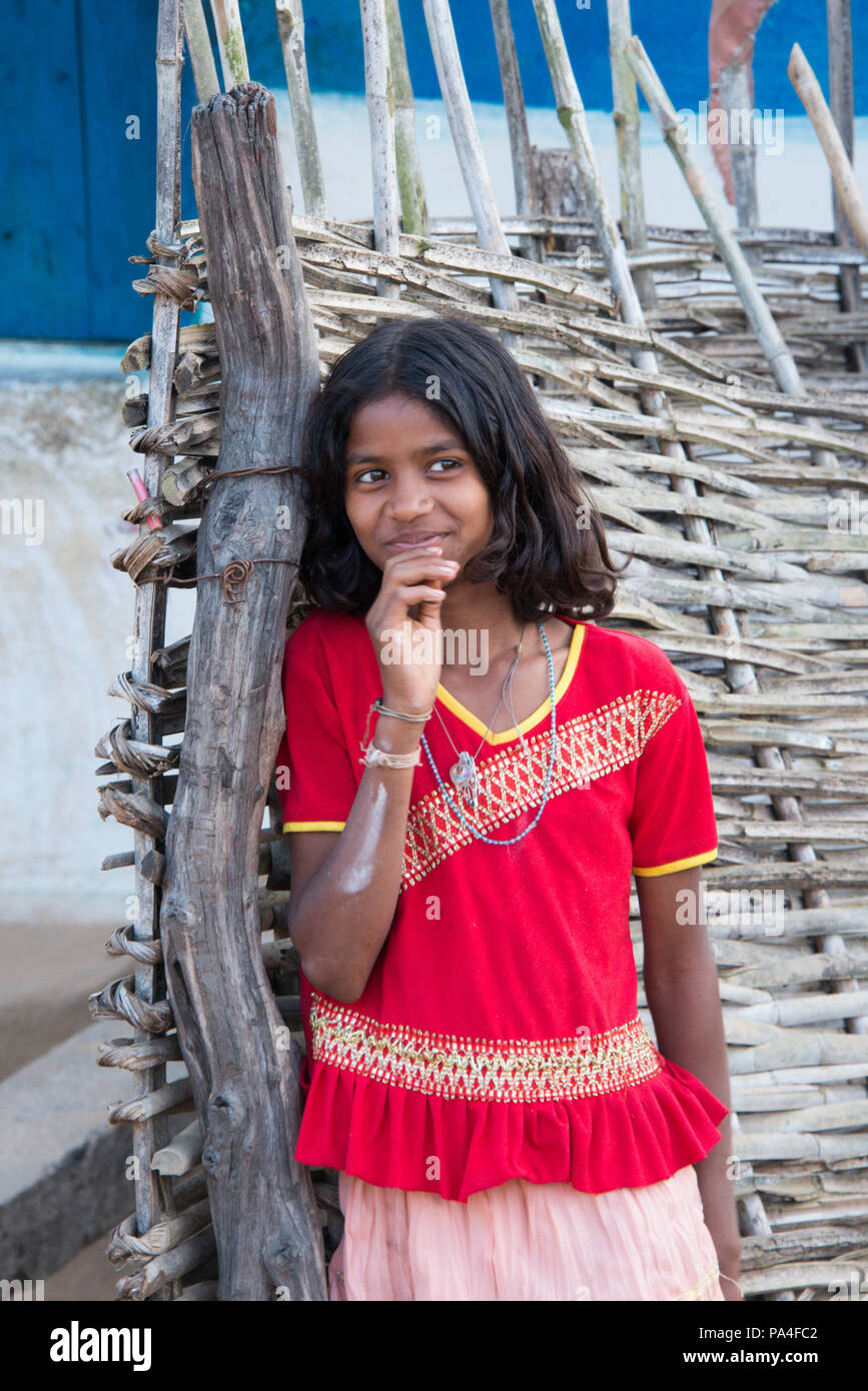 A local indian girl stands outside her house to see tourists walking by ...