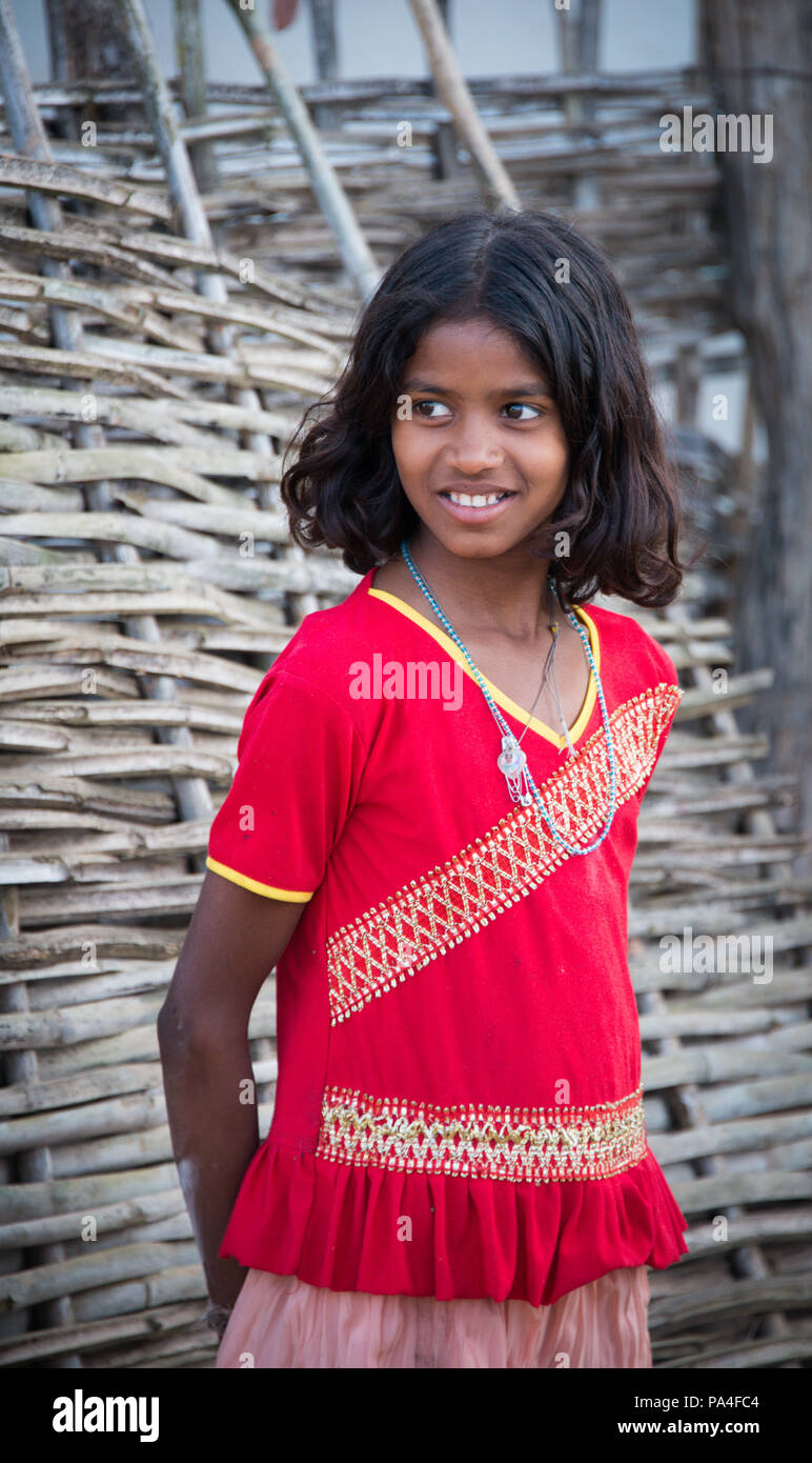 A local indian girl stands outside her house to see tourists walking by ...
