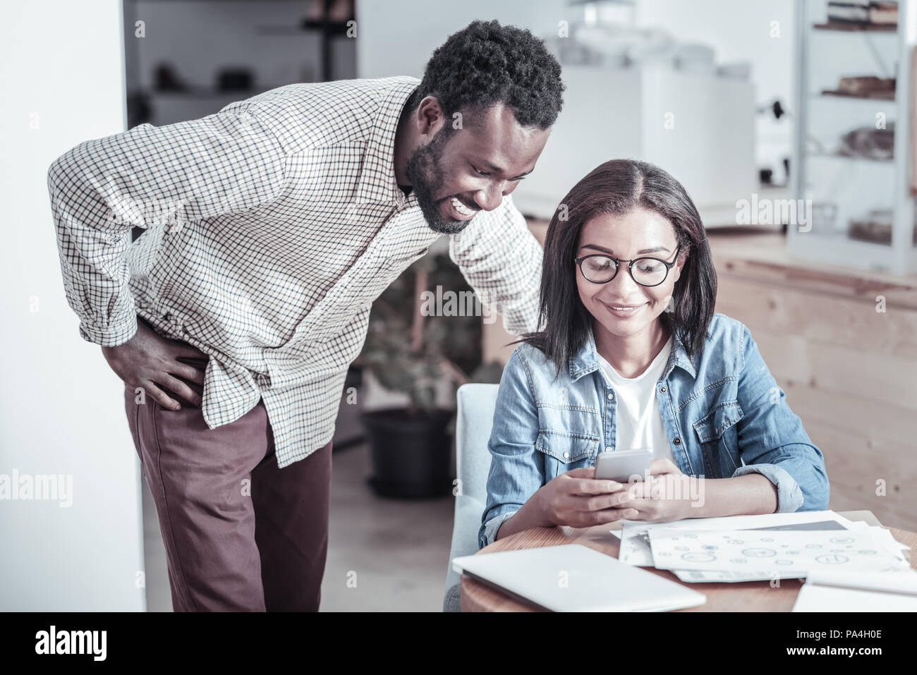 Nice happy man standing behind his friend Stock Photo - Alamy