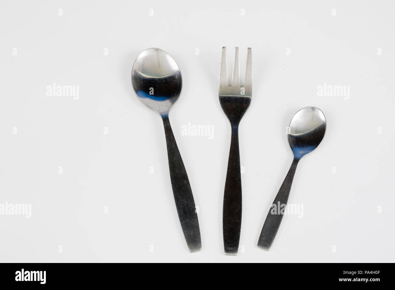 Cutlery arranged on a white kitchen table. Accessories for kitchen and ...