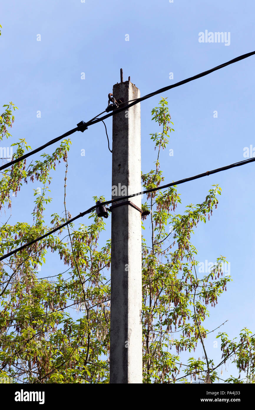 an old concrete column on which metal electrical wires are fixed ...