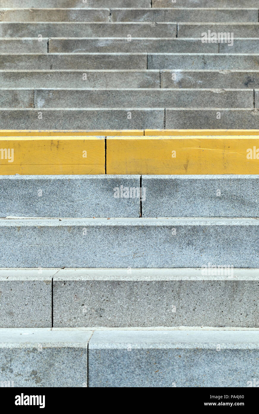 gray concrete staircase, one of the steps of which is painted yellow ...
