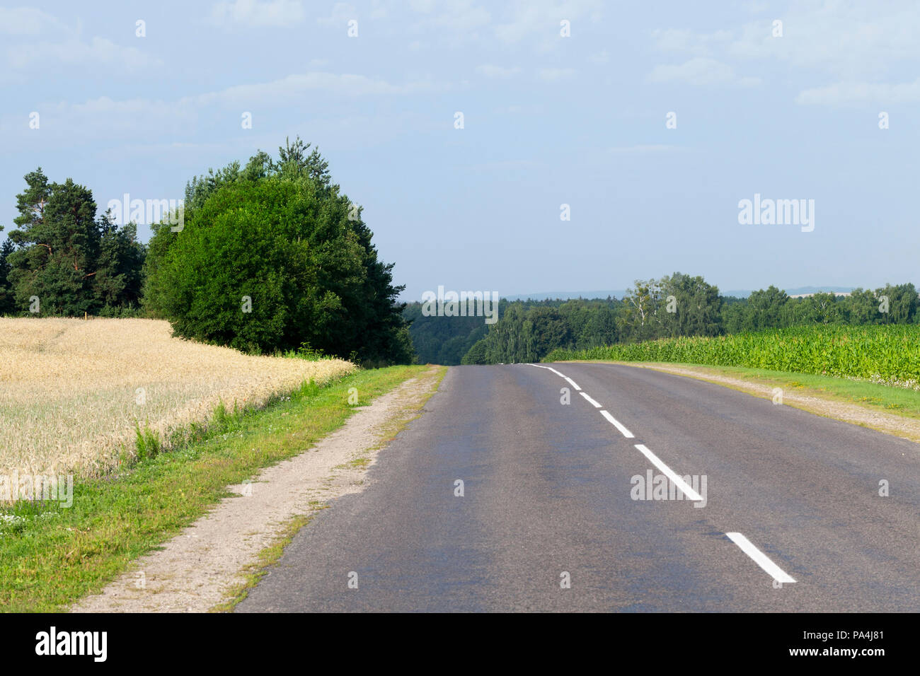 hilly terrain with an asphalt road, a landscape in the summer with ...