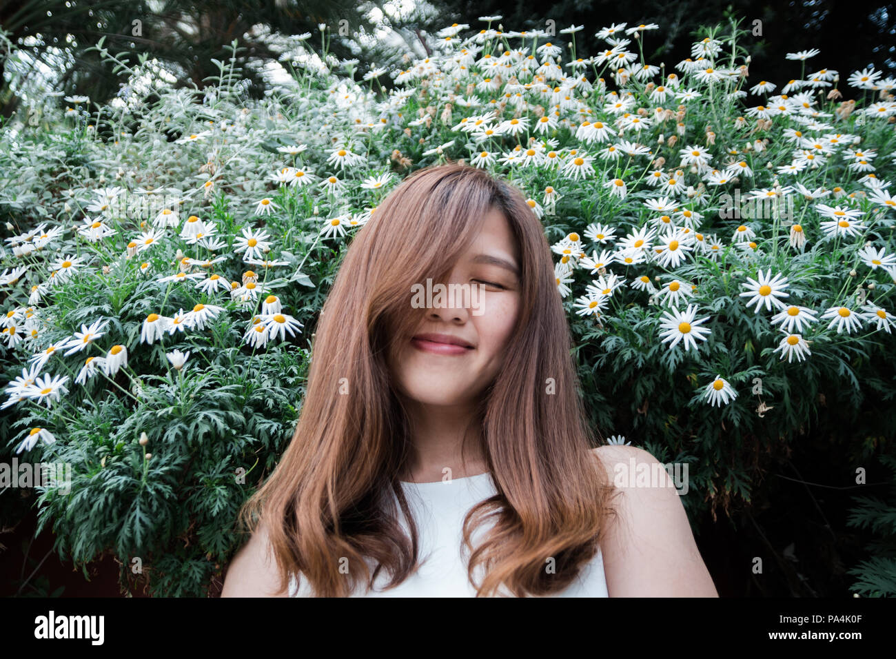 Portrait of beautiful and sweet Asian girl having fun with bushes of ...