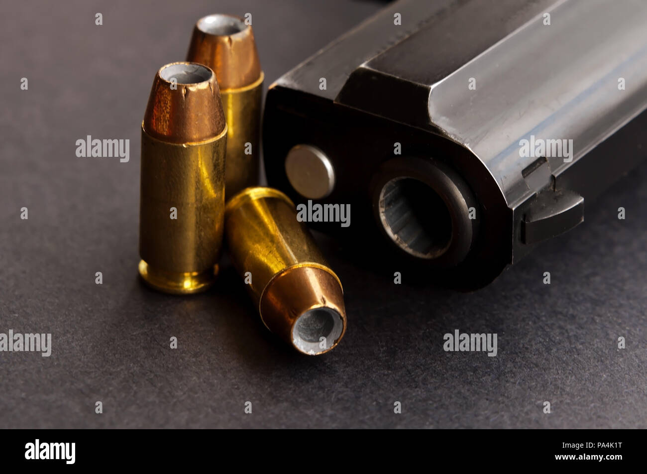 Three 40 caliber hollow point bullets on a black background with a ...