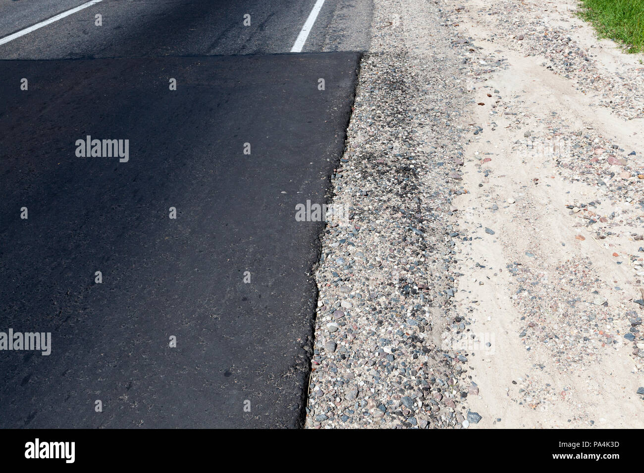 a simple asphalt road with new layers of asphalt, which repaired pits ...