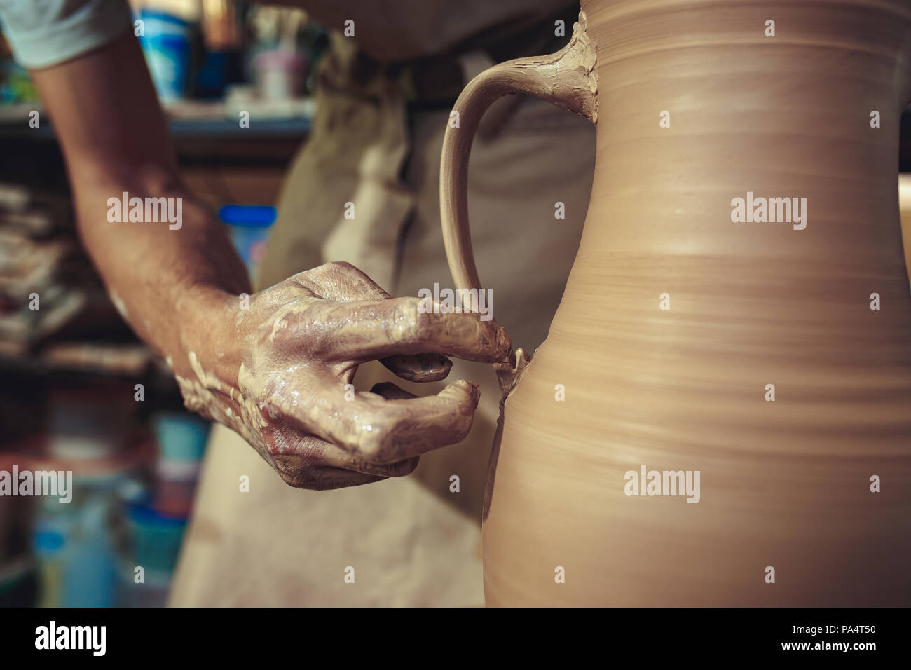 Creating a jar or vase of white clay close-up. Master crock. Man hands ...