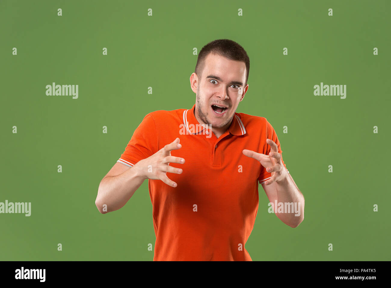 The young emotional angry and scared man standing and looking at camera ...