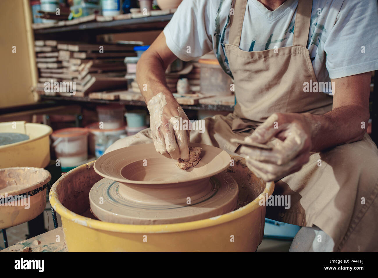 Creating a jar or vase of white clay close-up. Master crock. Man hands ...