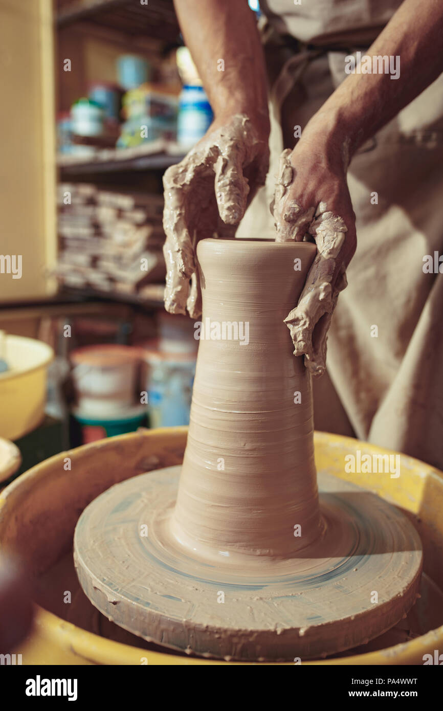 Creating a jar or vase of white clay close-up. Master crock. Man hands ...