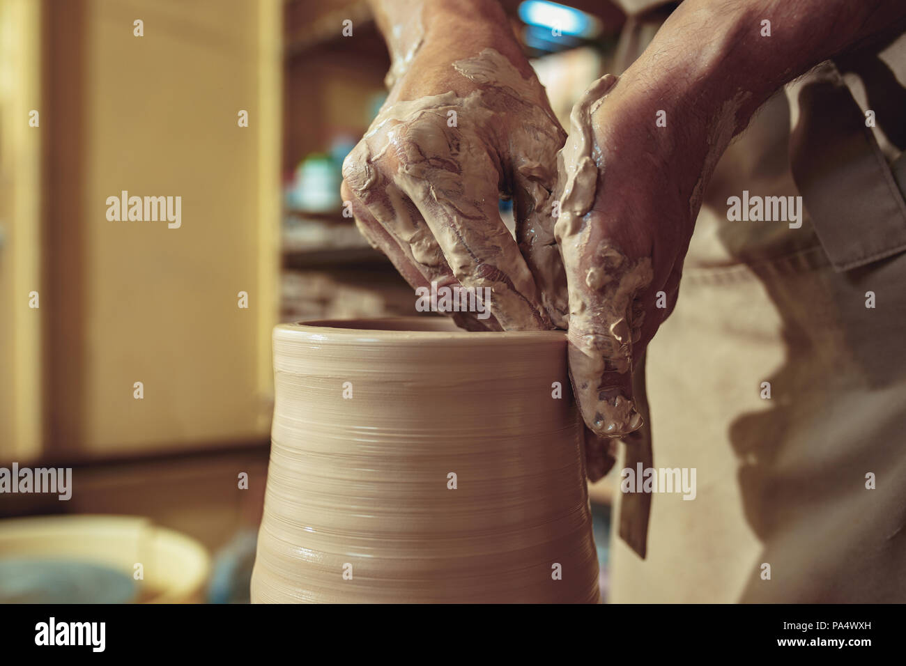 Creating a jar or vase of white clay close-up. Master crock. Man hands ...