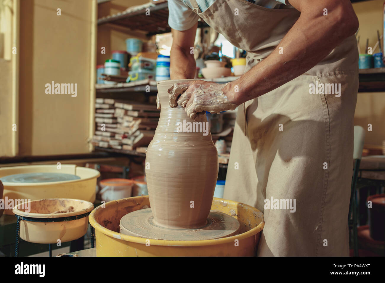 Creating a jar or vase of white clay close-up. Master crock. Man hands ...