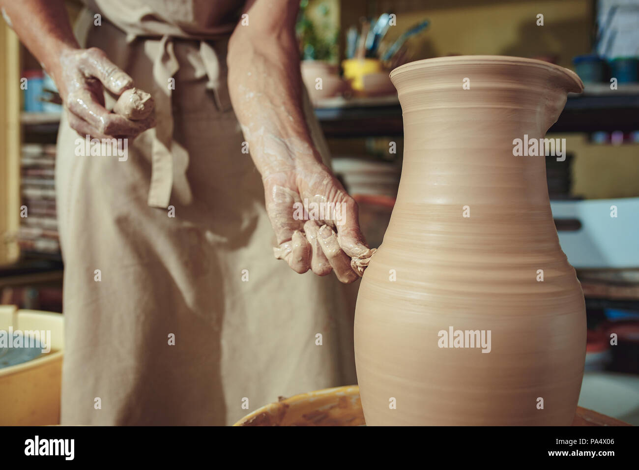 Creating a jar or vase of white clay close-up. Master crock. Man hands ...