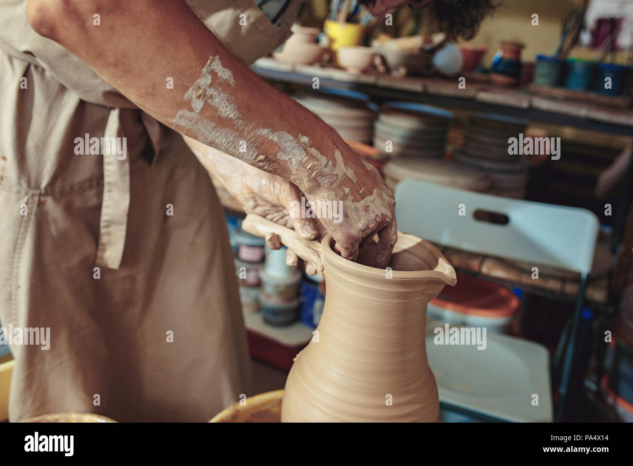 Creating a jar or vase of white clay close-up. Master crock. Man hands ...