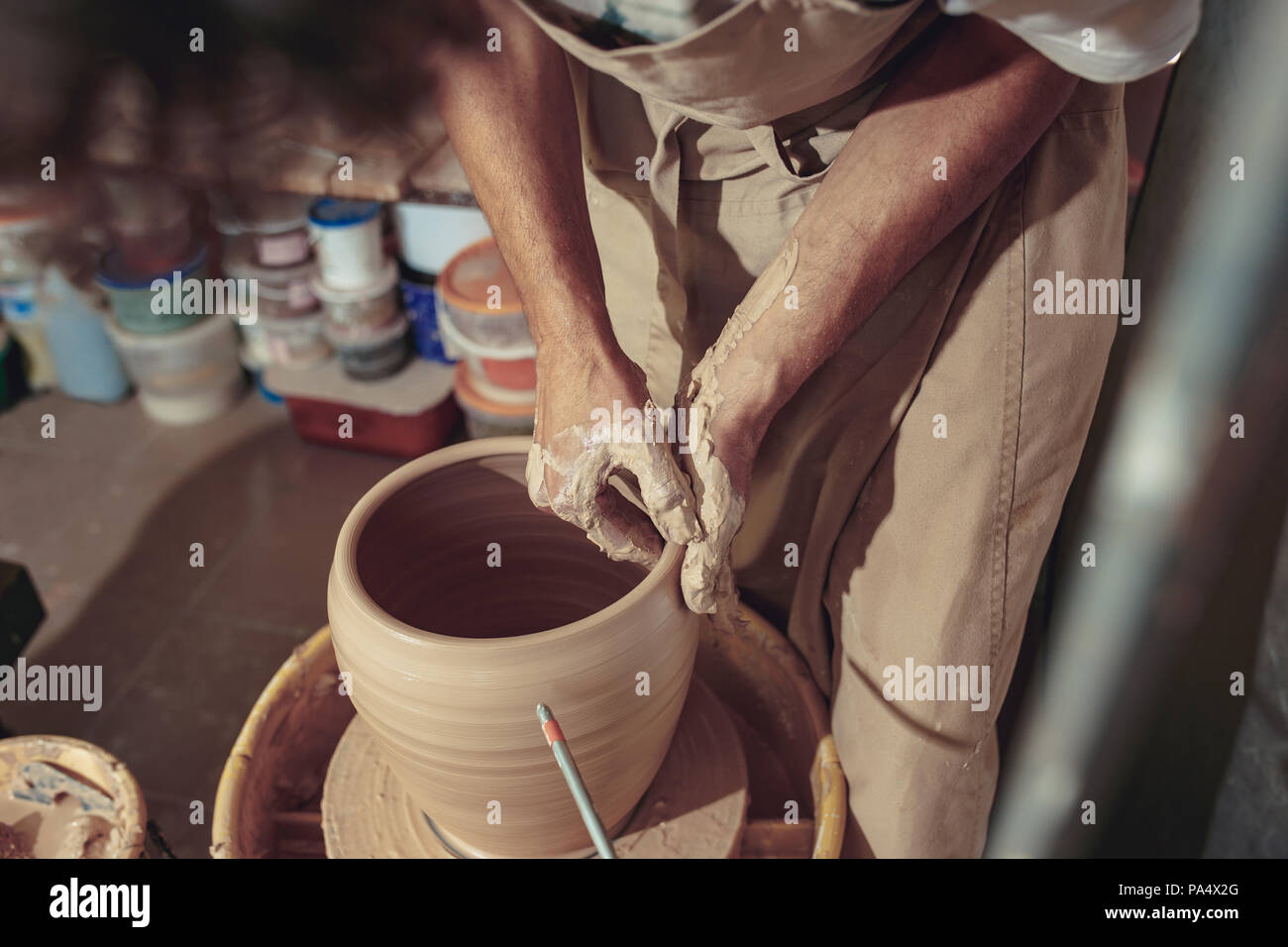 Creating a jar or vase of white clay close-up. Master crock. Man hands ...