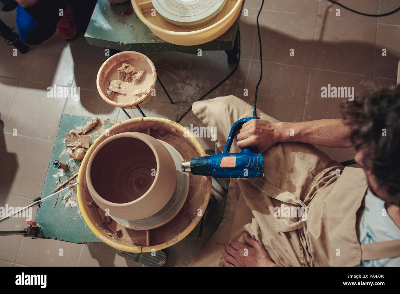 Creating a jar or vase of white clay close-up. Master crock. Man hands ...