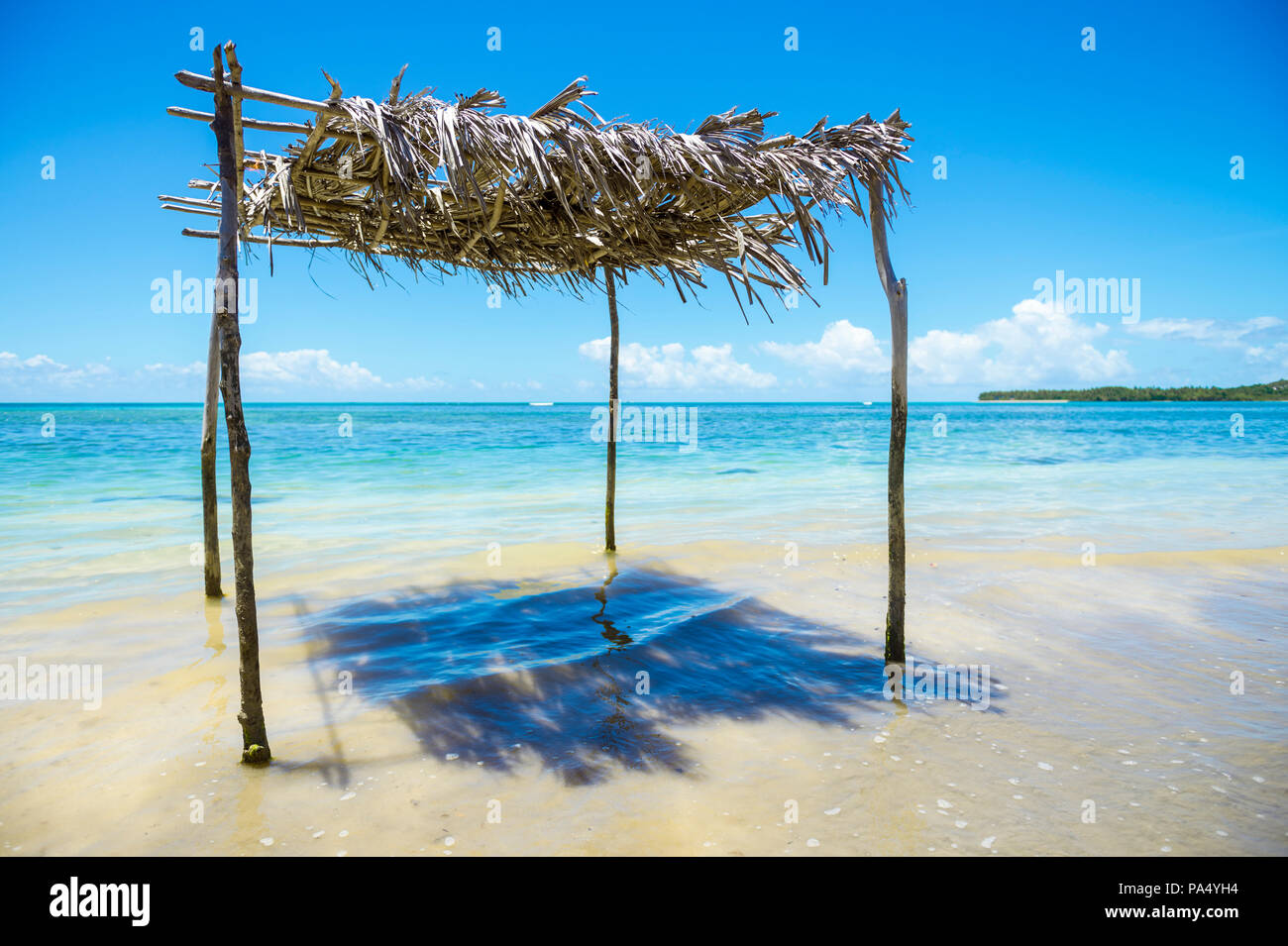 Rustic palm frond and tree branch palapa stands waiting to shade ...