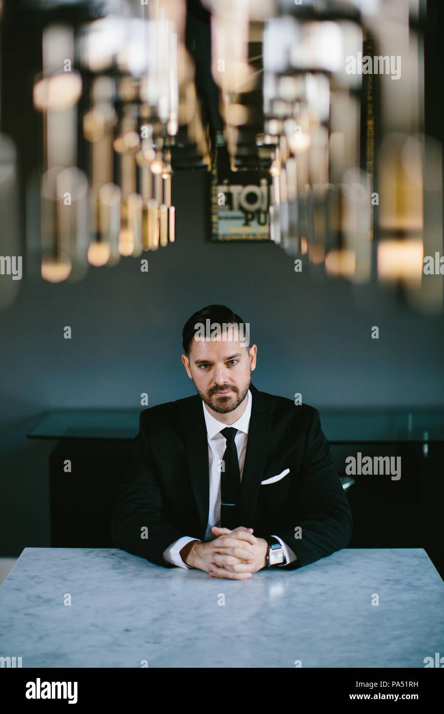 business man at table with hands folded Stock Photo - Alamy
