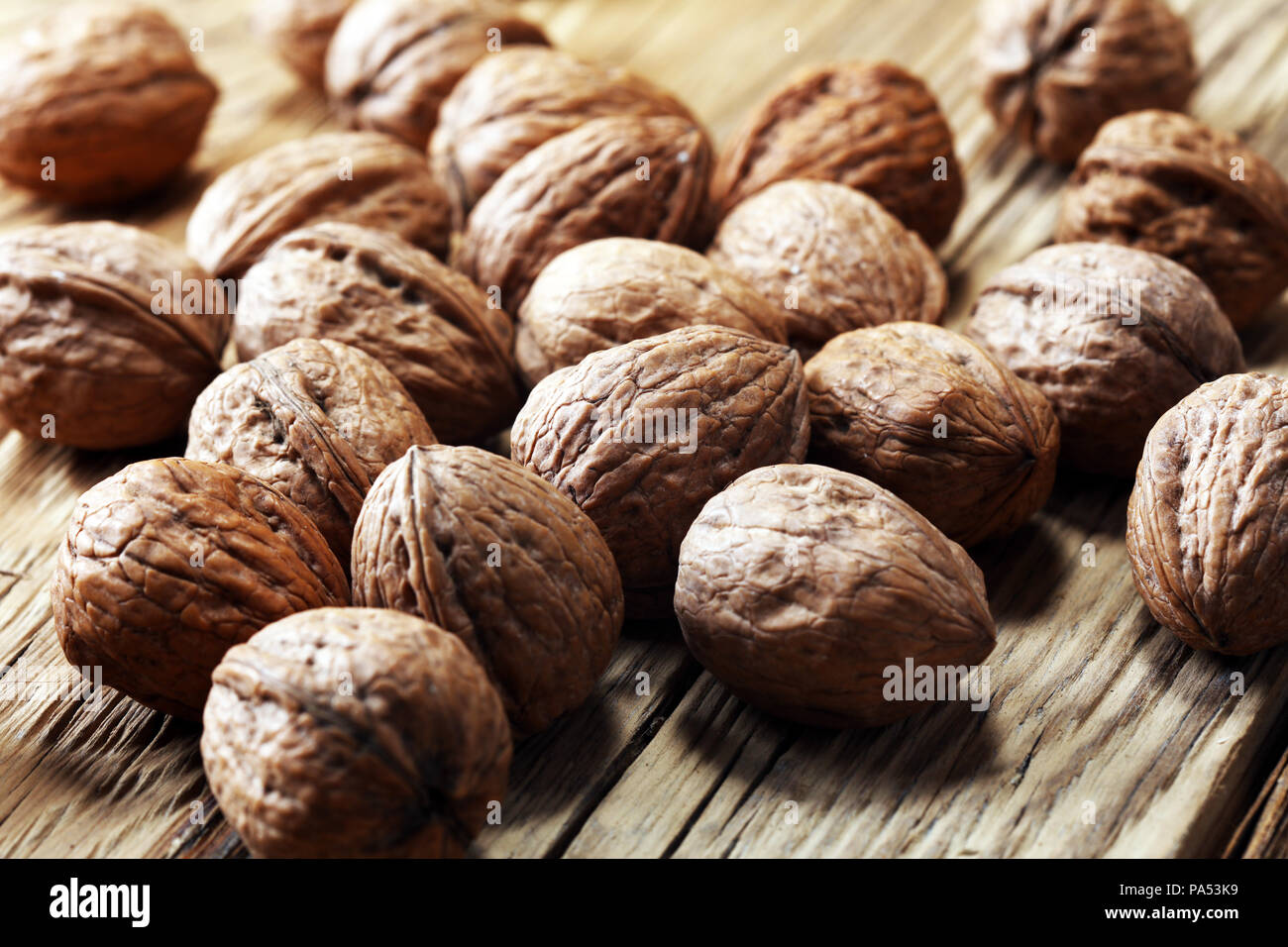 Walnut kernels and whole healthy walnuts on rustic old table Stock ...
