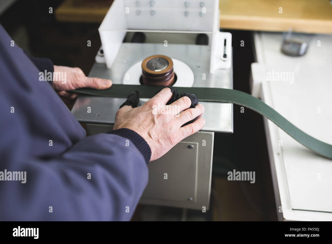Close up shot of worker's hands in leather belt making process Stock ...