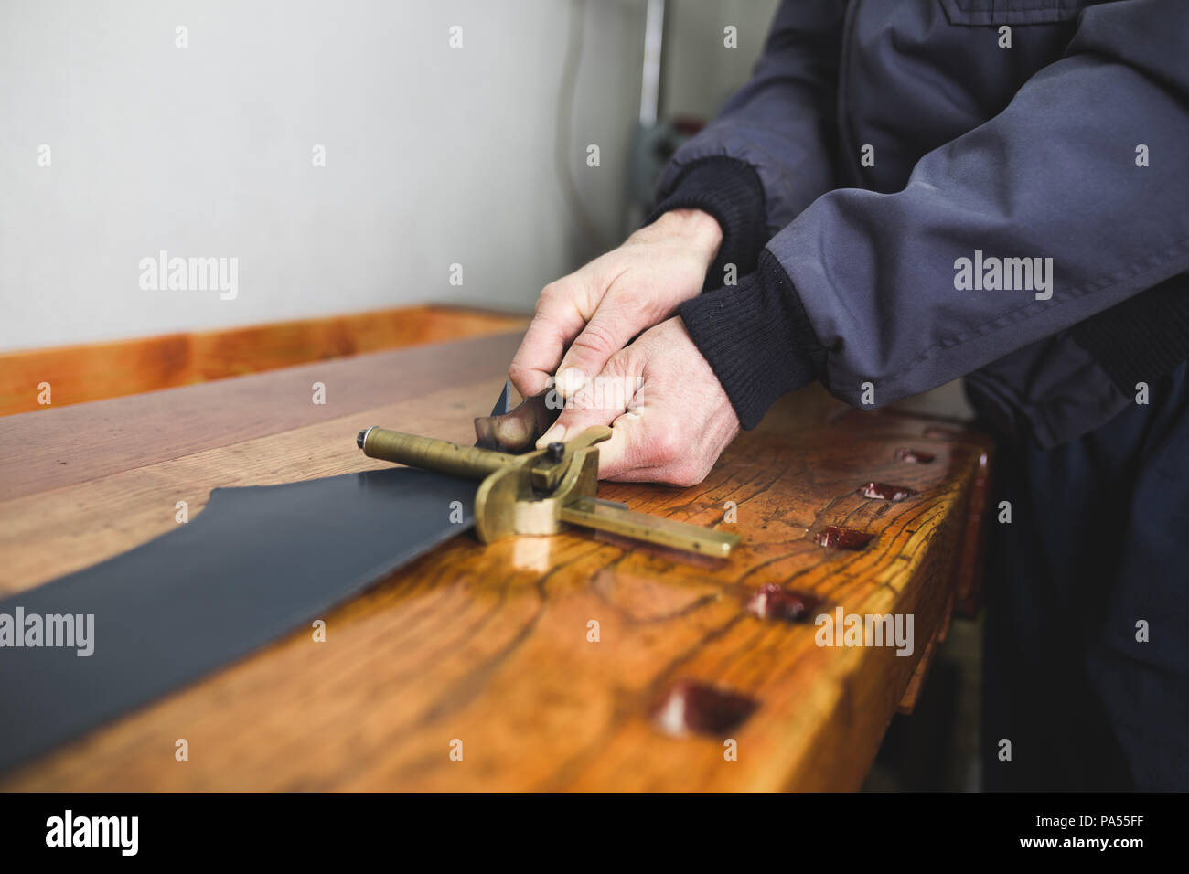 Close up shot of worker's hands in leather belt making process Stock ...