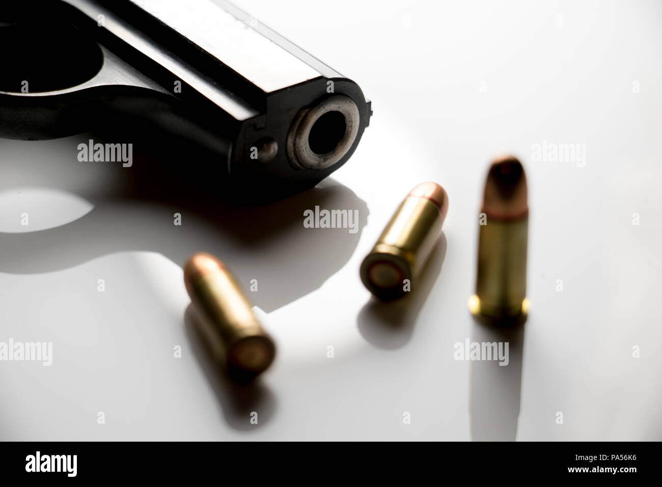 Gun close up with bullets reflecting on white surface. Isolated Gun and ...