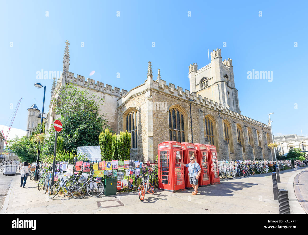 A man poses for a photograph at the iconic red pillar phone boxes ...