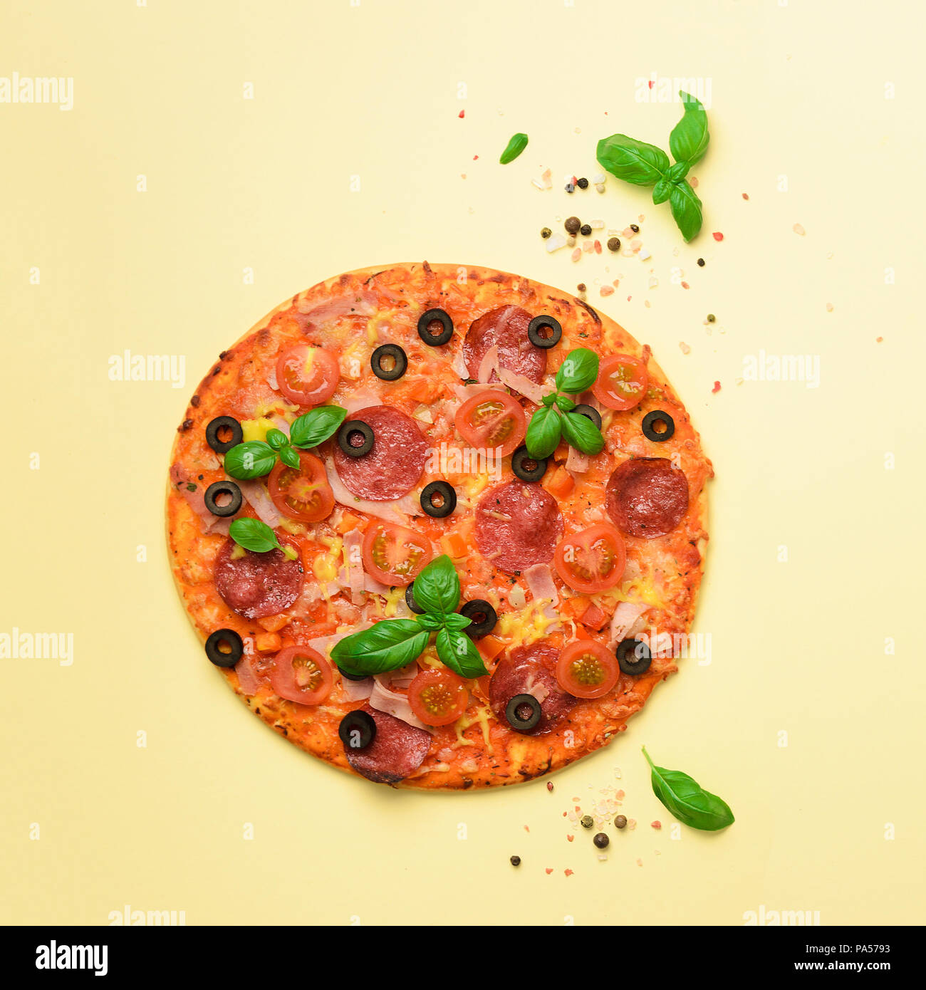 Delicious italian pizza, basil leaves, salt, pepper on yellow ...